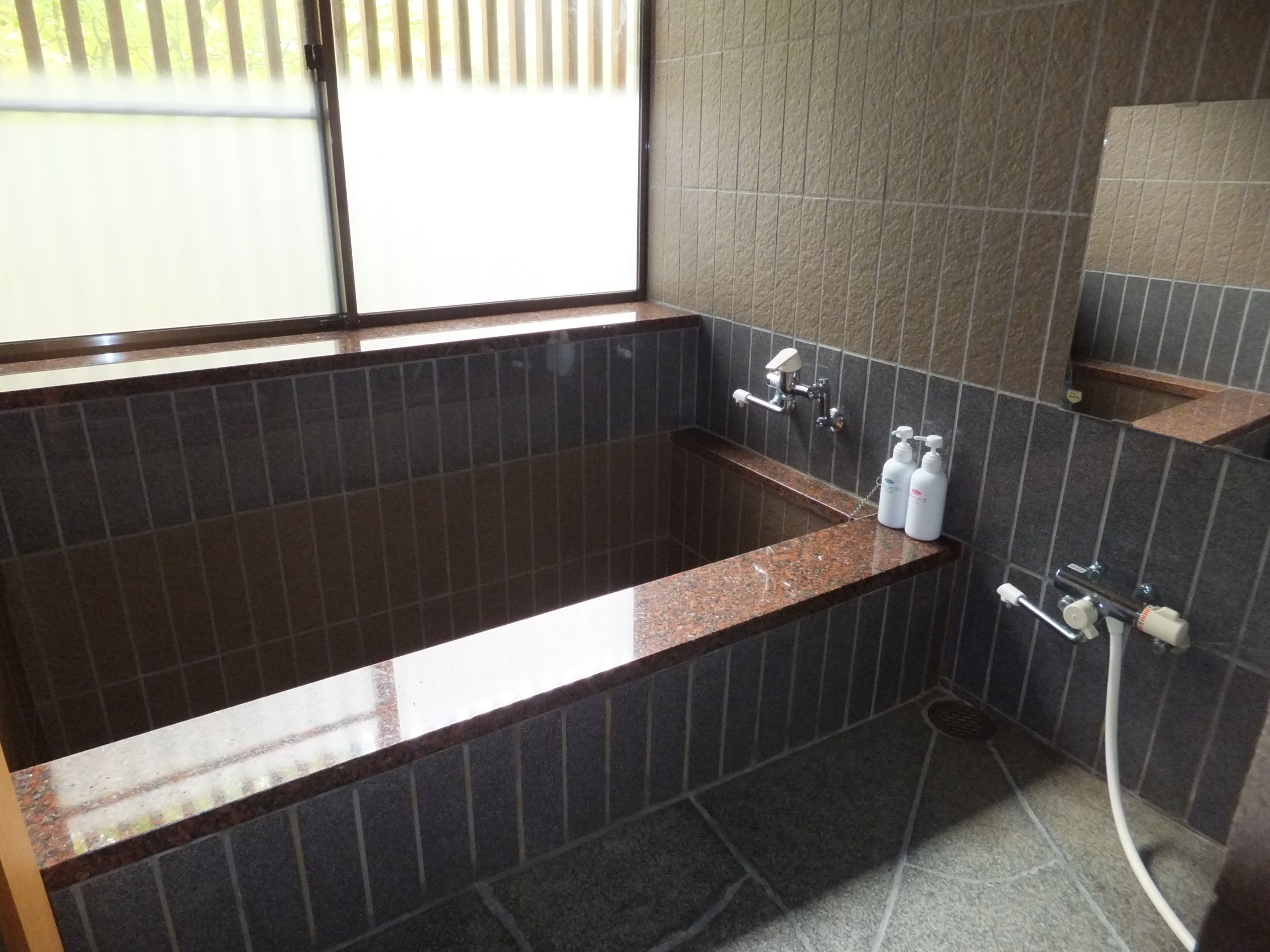 Casa de banho com uma banheira grande, chuveiro e espelho.