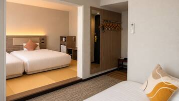 Quarto de hotel com cama, mesa de cabeceira, espelho e guarda-roupa.