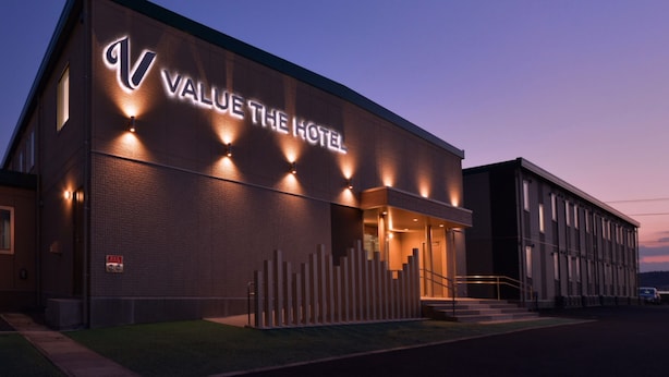 Edifício moderno de hotel com uma placa de destaque que diz "VALUE THE HOTEL".