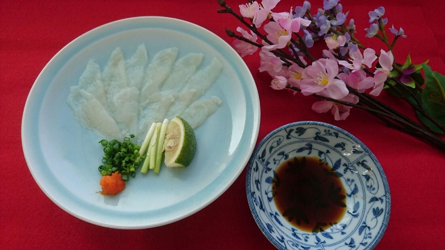 Um prato de comida com uma tigela decorativa e um pequeno recipiente com molho.
