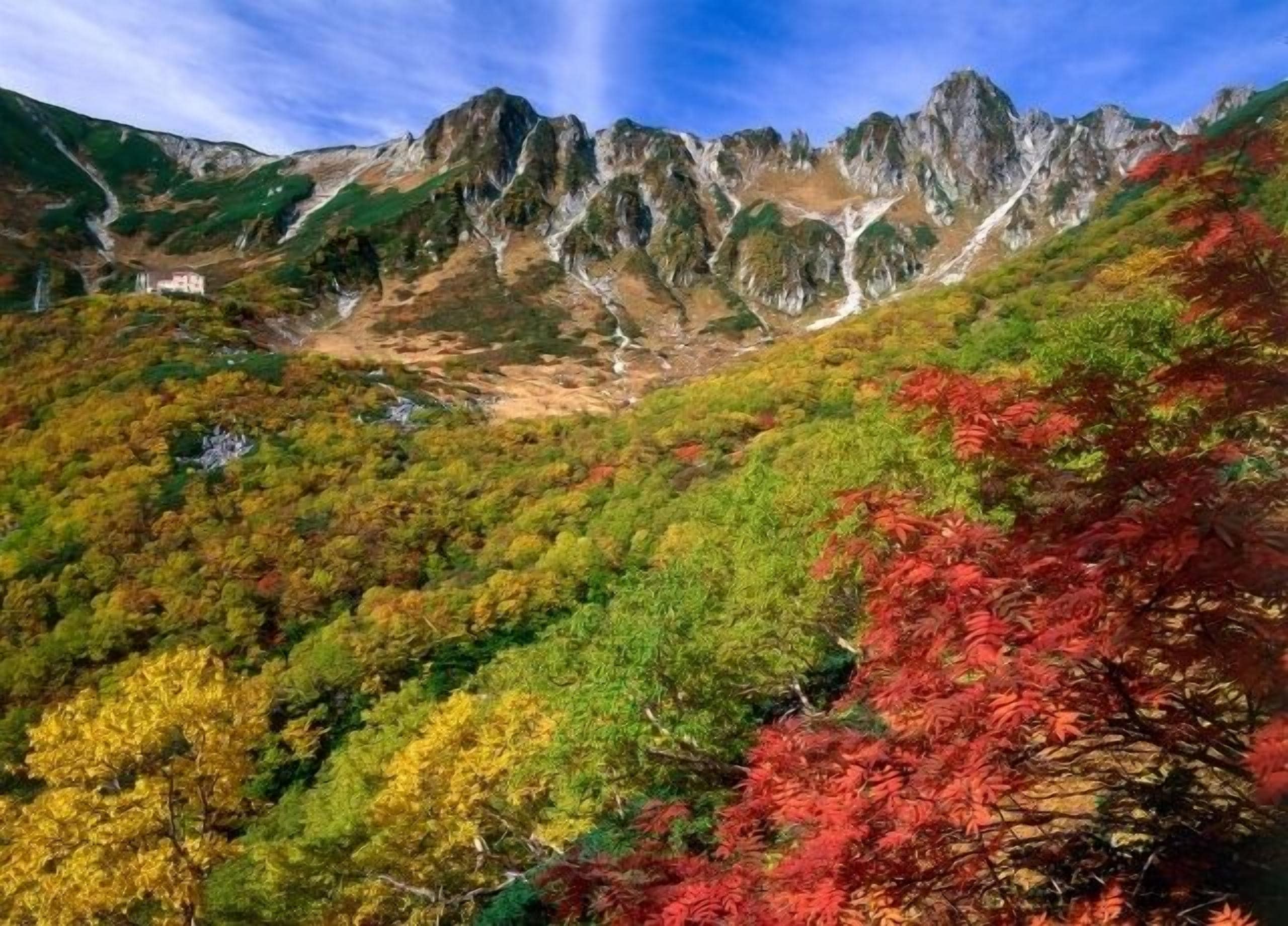Paisagem montanhosa com um vale e um edifício ao longe.