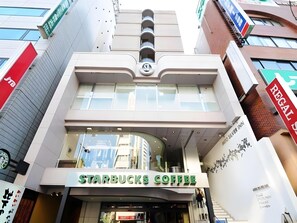Uma loja Starbucks com fachada moderna, grandes janelas e o logotipo bem visível acima da entrada.