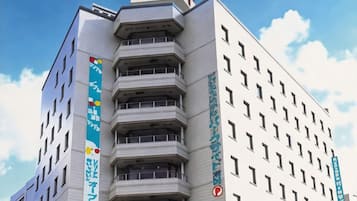 Um edifício com vários andares, fachada plana e uma série de varandas em cada pavimento.