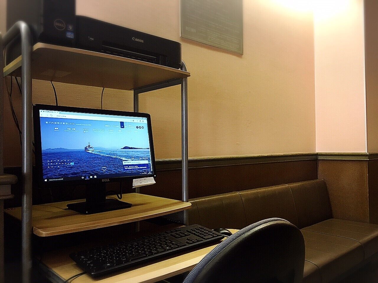 Configuração de computador sobre uma mesa de madeira, incluindo monitor, teclado e rato.