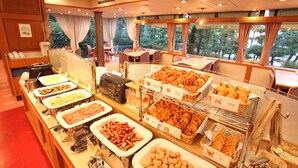 Buffet com diversos tipos de comida e área de refeições com mesas e cadeiras.