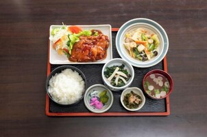Bandeja de refeição com diversos pratos, incluindo arroz, legumes e sopa.
