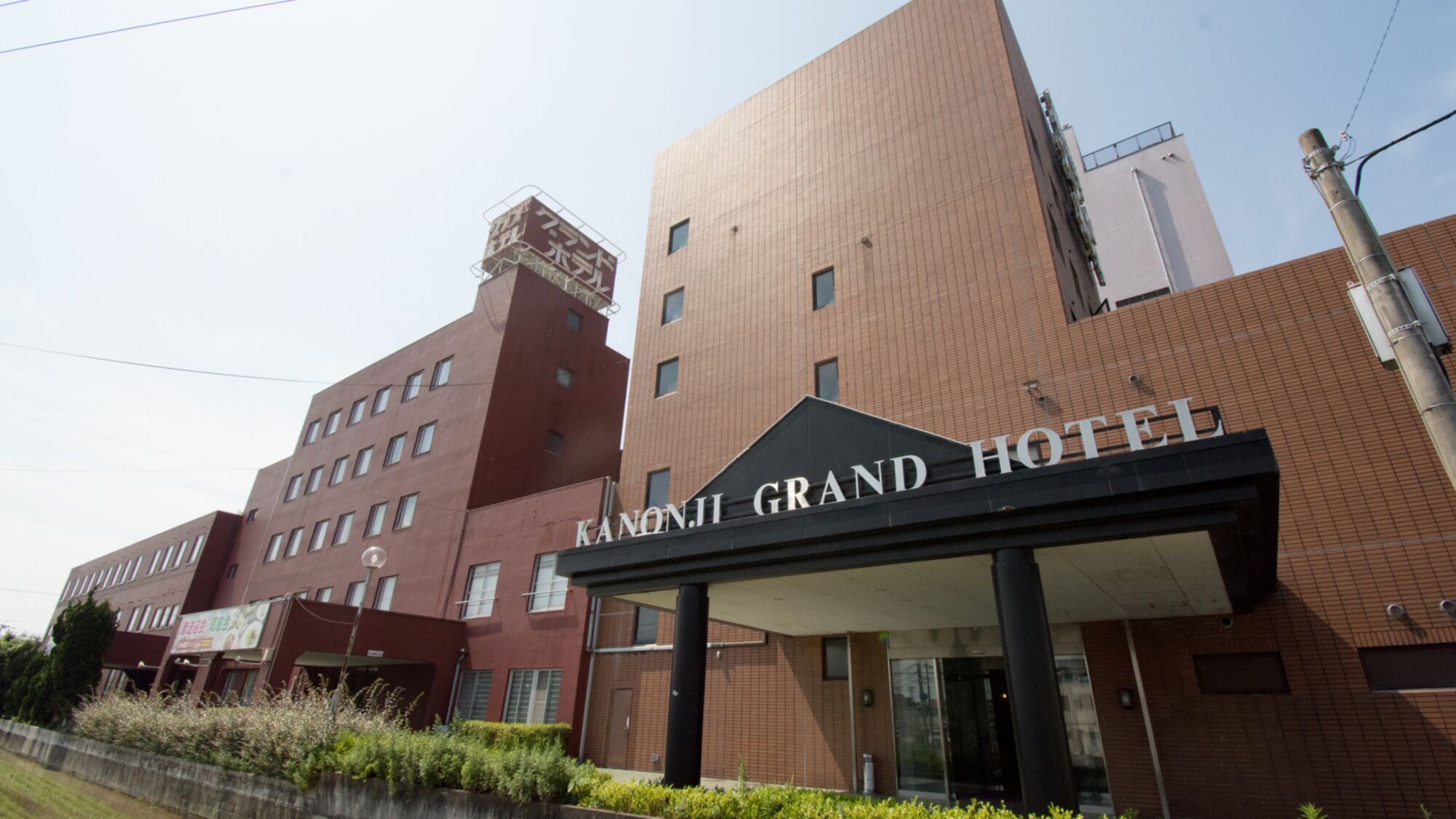 Um hotel com uma placa chamativa que diz "KANONJI GRAND HOTEL".