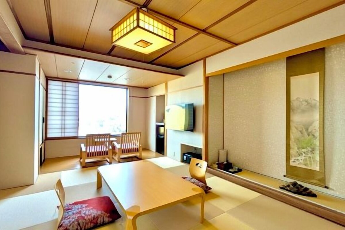 Um quarto japonês tradicional com tatames, uma mesa baixa e um portão deslizante.