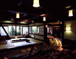 Um quarto japonês tradicional com tatame, biombos shoji e uma mesa baixa com cesta de palha.