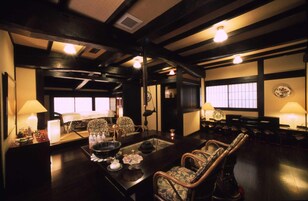 Quarto em estilo japonês tradicional, com tatames, mesinhas baixas e cadeiras. Possui portas de correr, lareira e uma grande janela.