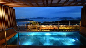 Piscina interior moderna com vista para um corpo de água e ilhas distantes.