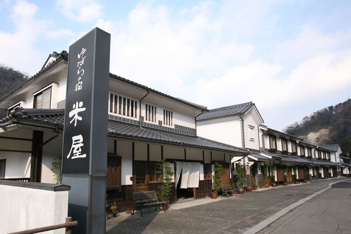 Um edifício tradicional japonês com uma placa que indica ser um ryokan.