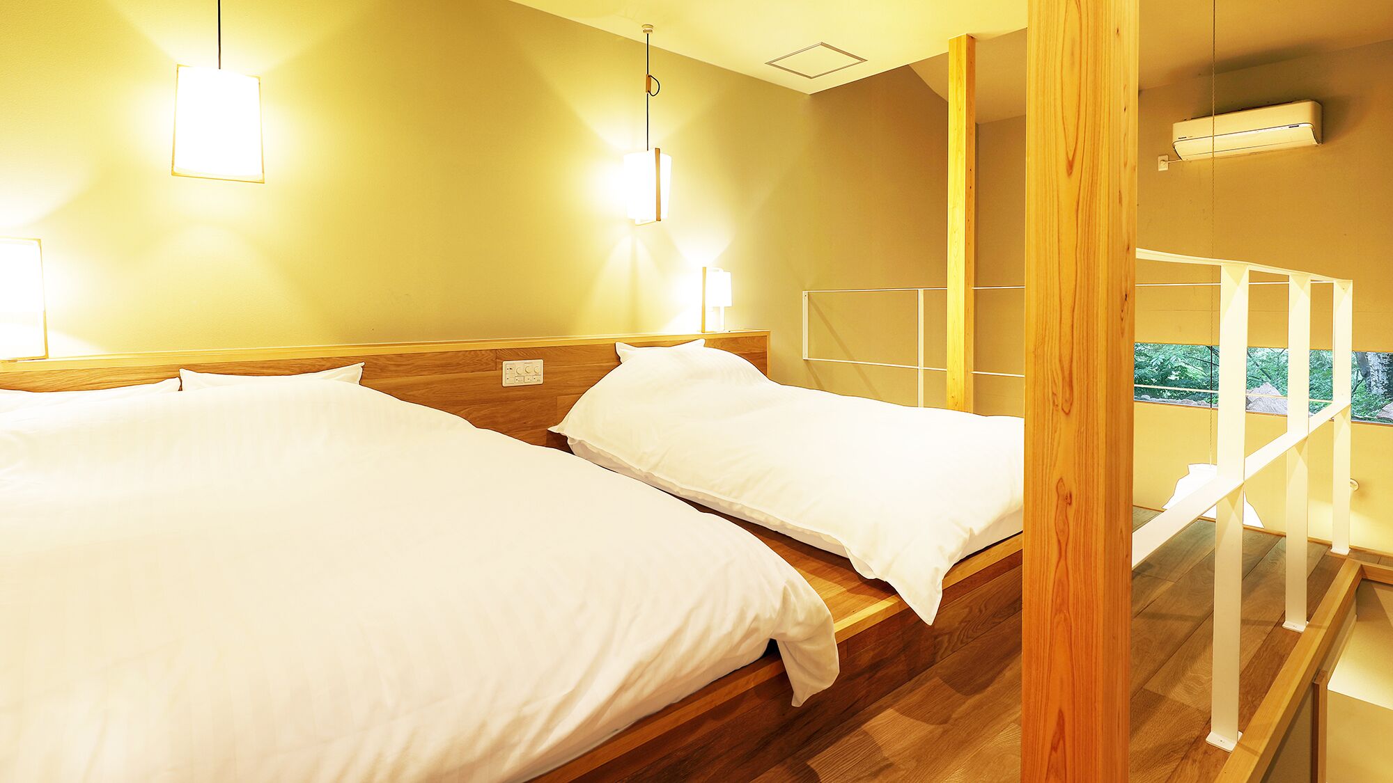 Quarto de hotel com duas camas, cabeceiras de madeira e varanda com vista.