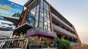Um edifício moderno com um grande outdoor anunciando uma garantia de automóvel.