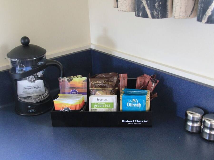 Uma estação de café com uma cafeteira, um porta-cápsulas e um moedor de café.
