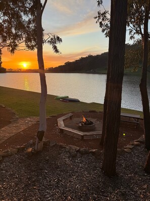 Vista para o lago com lareira e mesa de piquenique.