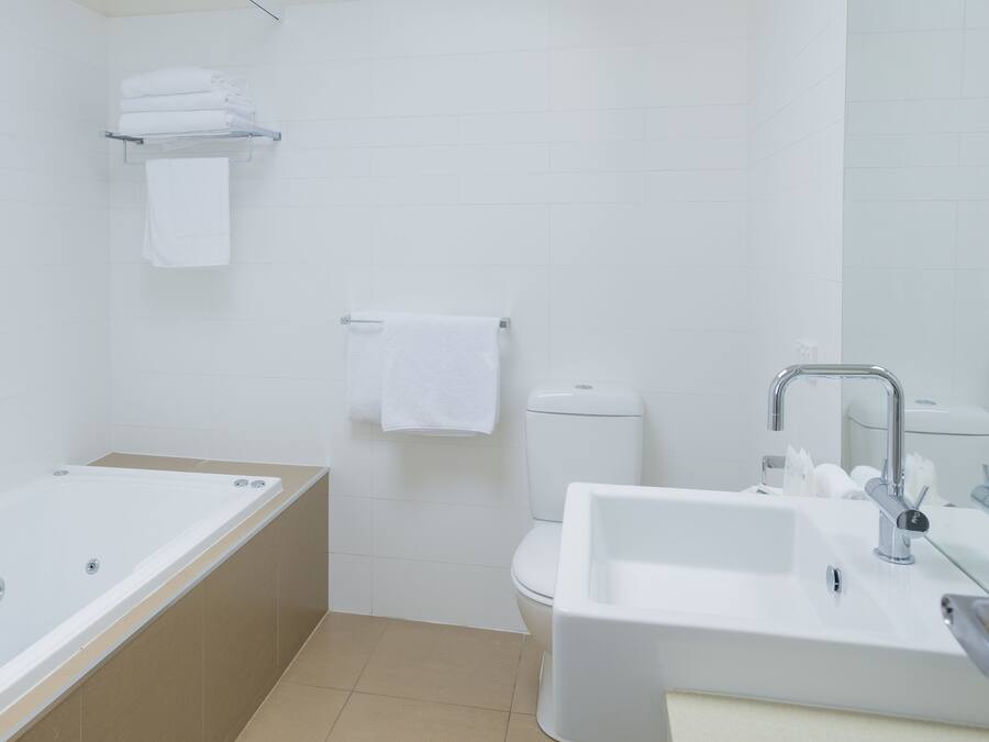 Um banheiro moderno com banheira, vaso sanitário e pia.