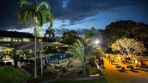 Hotel com piscina, área de estar externa e espaço coberto.