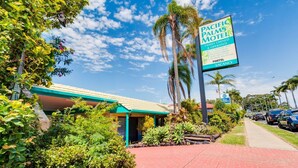Um motel com uma placa indicando que é de propriedade familiar e oferece comodidades como estacionamento, piscina e restaurante.
