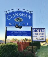 Placa do Clansman Motel com comodidades como estacionamento coberto, camas e chuveiros superiores, café da manhã e jantar, e Wi-Fi gratuito.
