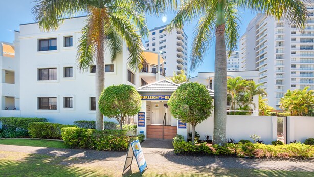 Um hotel moderno com um aviso indicando apartamentos para férias e quartos disponíveis.