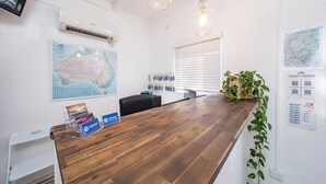 Uma área de recepção com uma mesa de madeira, um mapa na parede e uma planta no balcão.