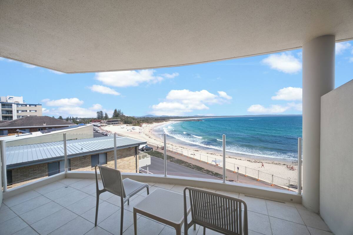 Uma varanda com vista para a praia e o oceano.