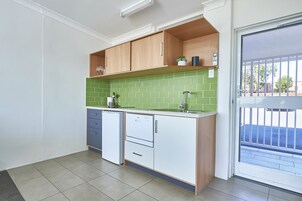 Uma cozinha compacta com lava-louças, pia e bancada pequena.