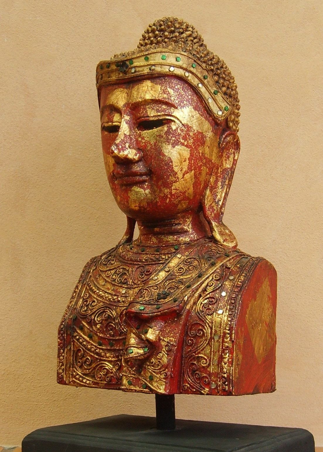 Um busto dourado com desenhos complexos e joias.