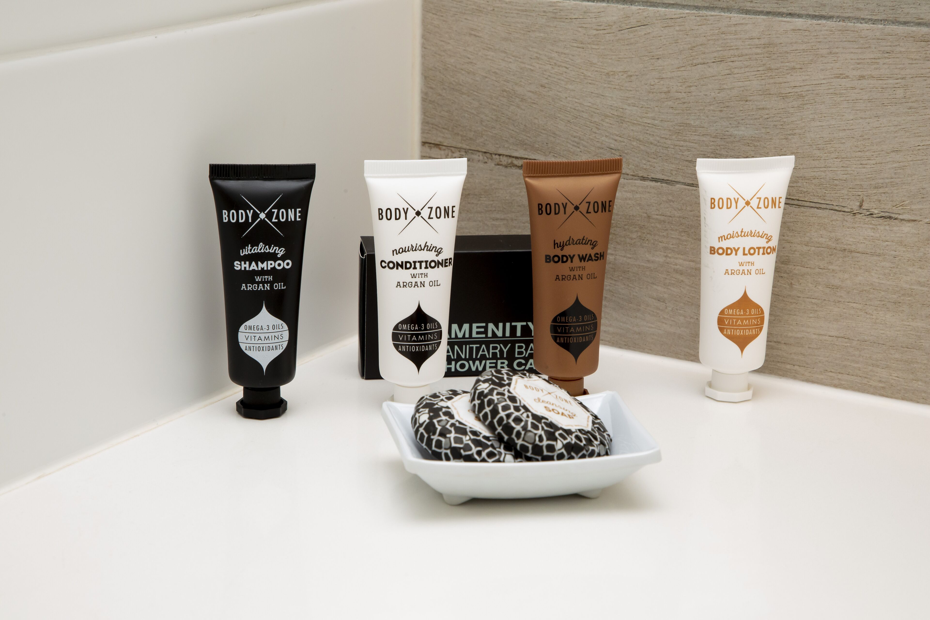 Quatro produtos de cuidados para o corpo da Body Zone sobre uma superfície branca.