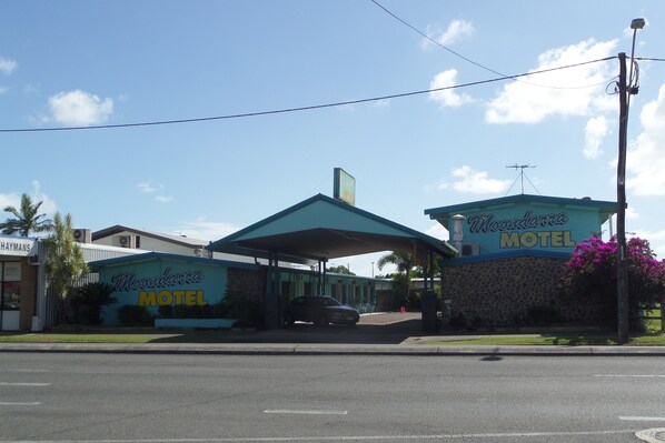 Um motel com teto azul e uma placa que diz 'Moondarra Motel'.