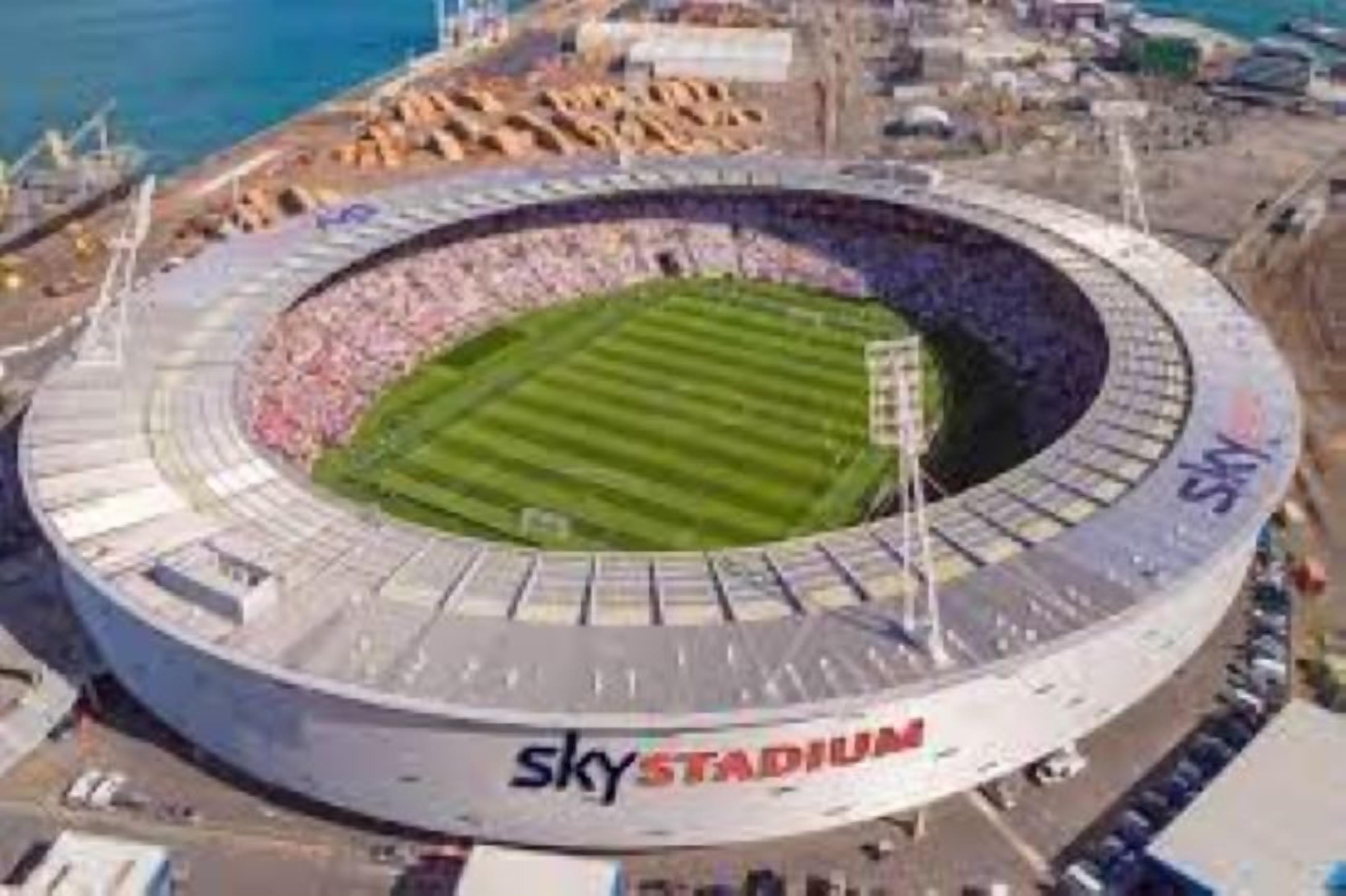 Um estádio com design circular, chamado "Sky Stadium", com um campo central e assentos em níveis.