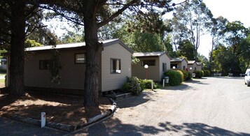 Uma fileira de casas móveis com um caminho de cascalho e árvores.