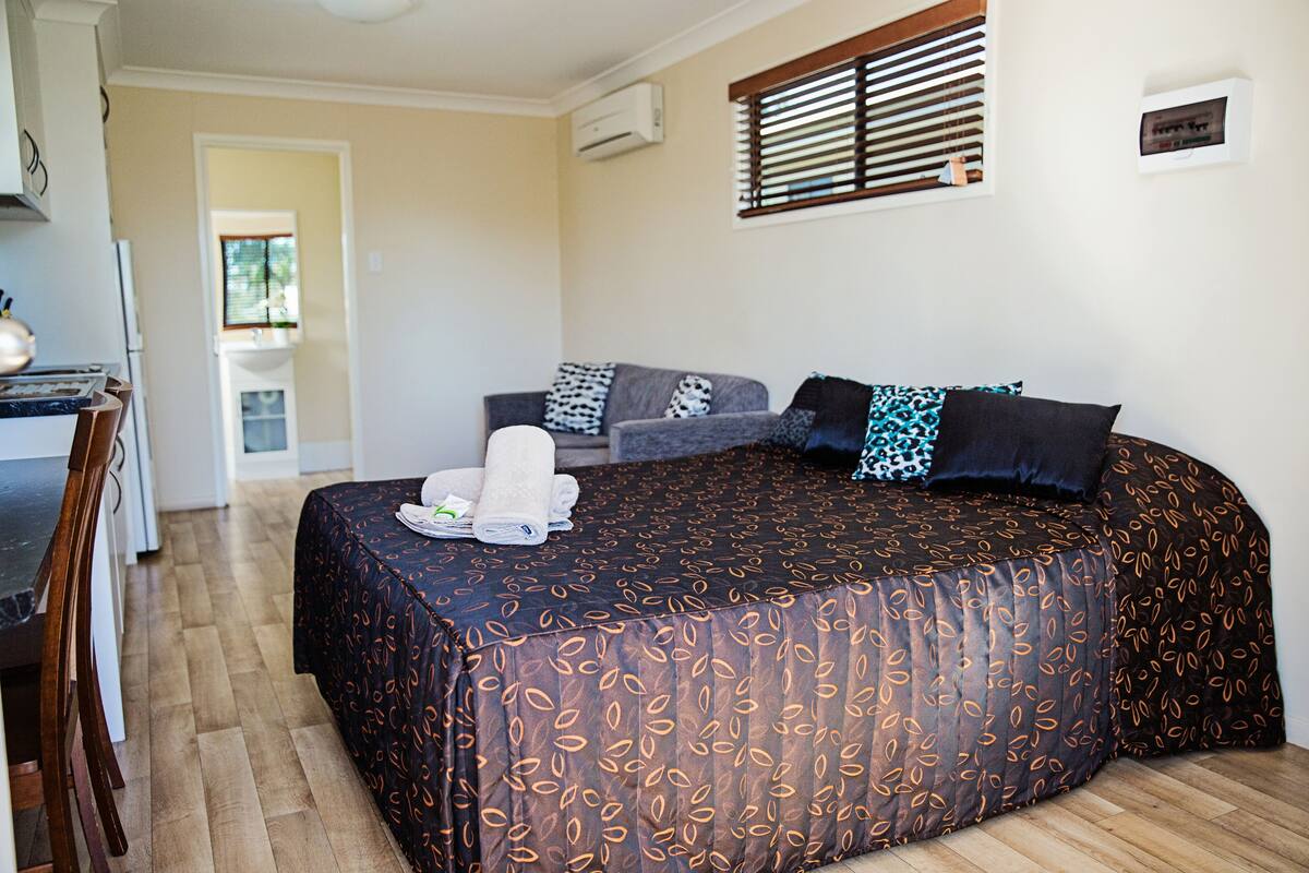 Um quarto com cama, escrivaninha e cadeira.