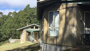 Uma casa de dois andares com chaminé, janelas amplas e varanda coberta.