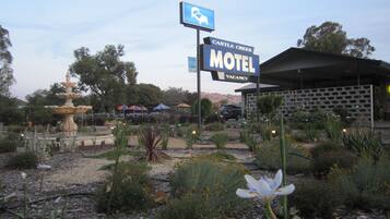 Placa de motel com uma fonte e um jardim em primeiro plano.