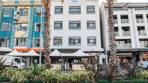 Um hotel com fachada moderna, vários andares e telhado plano.