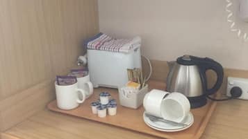 Um frigorífico, uma cafeteira/bule, uma chaleira elétrica