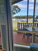 Vista de um quarto com janela para um parquinho com escorregadores e brinquedos.