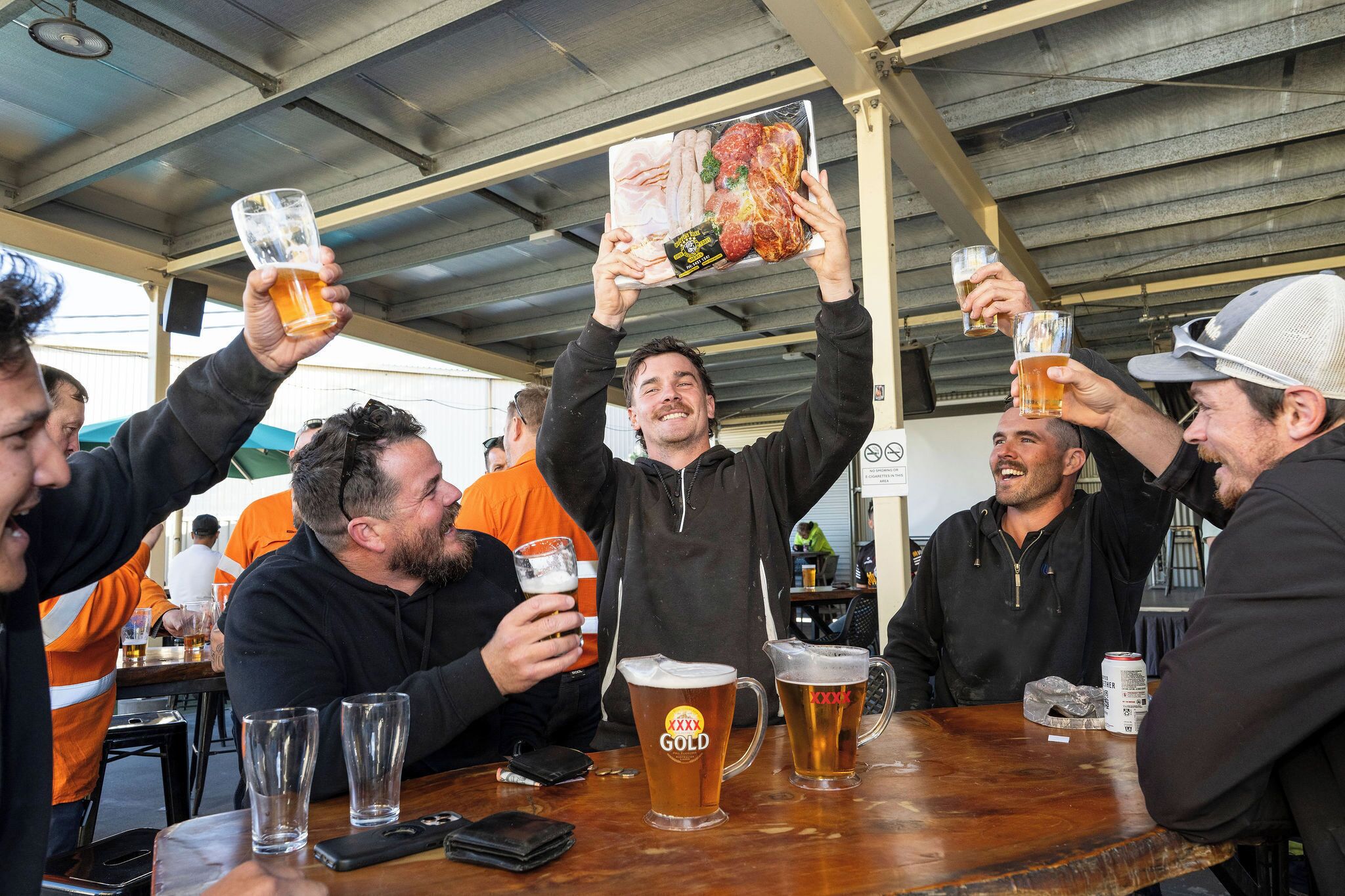 Um grupo de pessoas num bar, com canecas de cerveja e um menu.