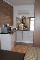 Um frigorífico, um micro-ondas, uma cafeteira/bule 