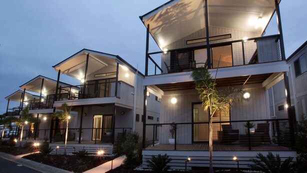 Um edifício residencial moderno, de vários andares, com varandas e grandes janelas.