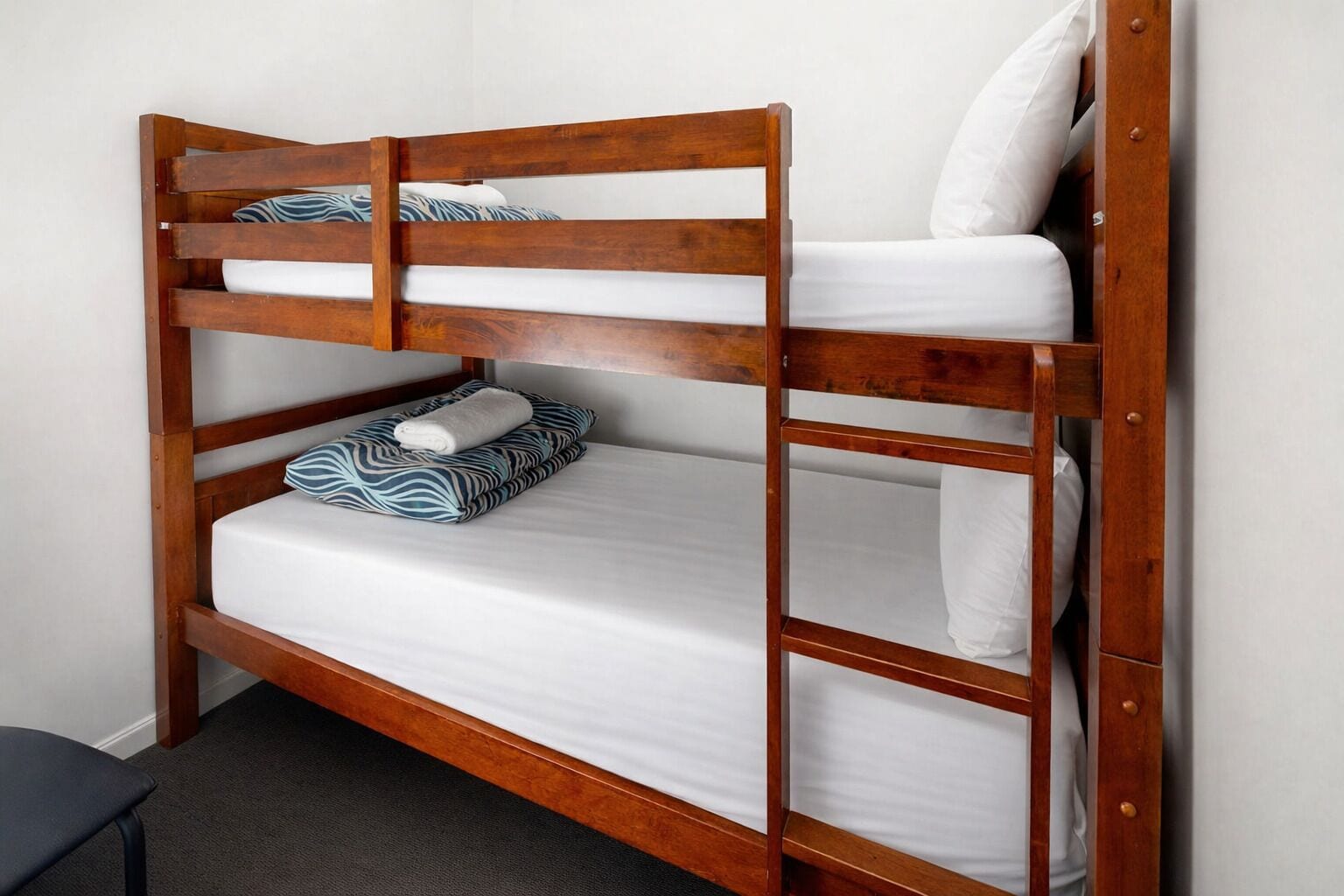 Uma cama beliche com roupa de cama branca e almofadas listradas.