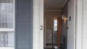 Porta que dá para uma cozinha com armários e bancada.