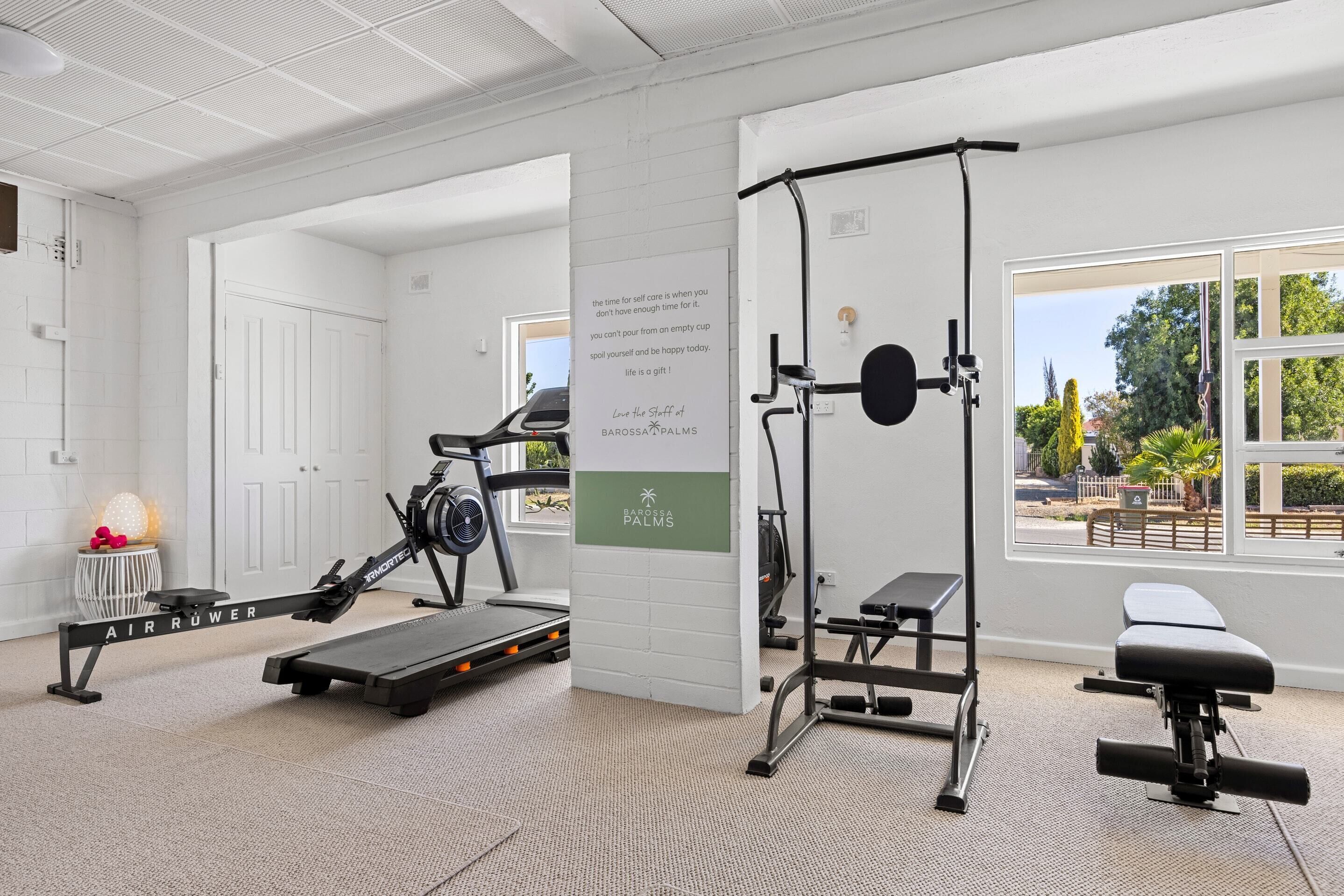 Uma academia moderna com equipamentos de cardio, máquinas de peso e um banco.