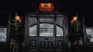Uma porta de madeira escura com uma placa acima que diz 'Bellazona'.