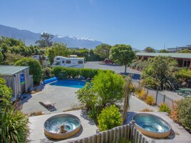 Zona residencial com piscina, banheiras de hidromassagem e uma caravana ao fundo.