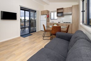 Um apartamento moderno com sala de estar, sala de jantar e cozinha.