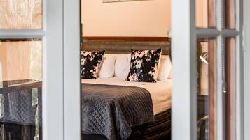 Quarto de hotel com cama, almofadas e um quadro na parede.