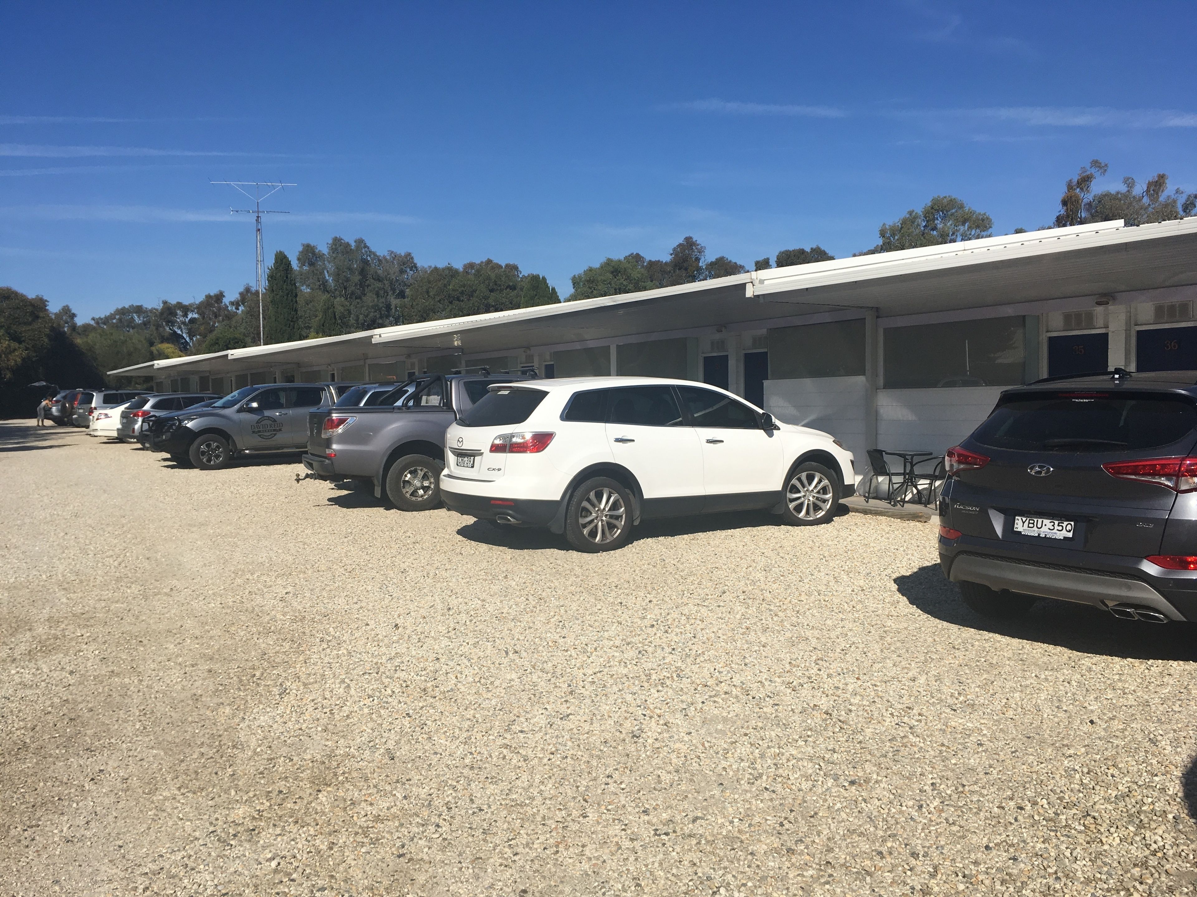 Um estacionamento com vários carros estacionados em frente a um edifício com várias garagens.